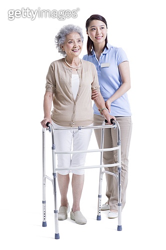 Female nursing assistant helping senior woman with walking frame 이미지 ...