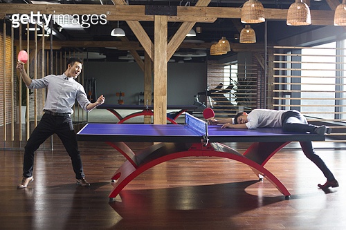 Young businessmen playing ping pong 이미지 (a10744845) - 게티이미지뱅크