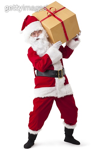 Santa Claus carrying heavy gift box on shoulder (a10786192) - 게티이미지뱅크