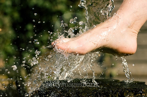 Splash of cold water showered on feet in an alternative therapy session ...