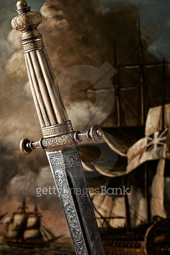 A close-up of an ancient carved sword against painted background. A ...