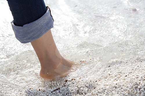 Person dipping toes into water at beach 이미지 (a10905826) - 게티이미지뱅크