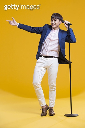 Cheerful young Chinese man singing with microphone 이미지 (a11095383) - 게티 ...