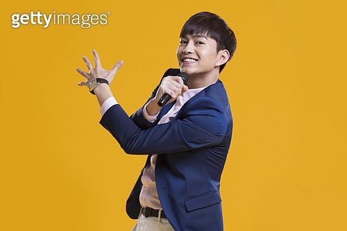 Cheerful young Chinese man singing with microphone 이미지 (a11095390) - 게티 ...