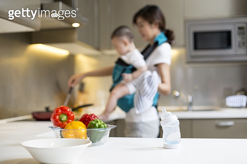 Chinese mother holding baby and cooking in the kitchen 이미지 (a11095845 ...