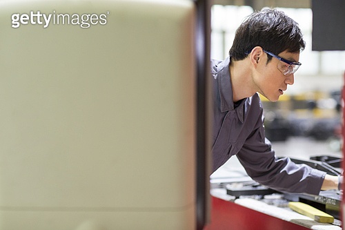 Young Chinese engineer working in the factory 이미지 (a11095909) - 게티이미지뱅크