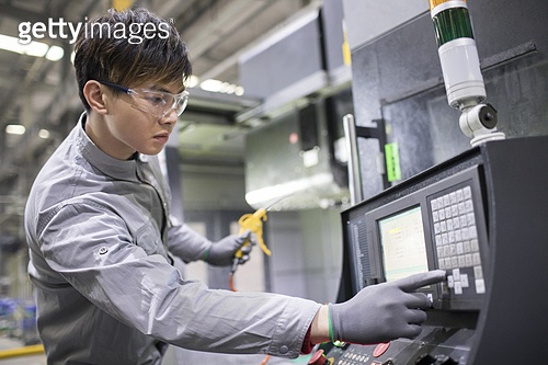 Confident Chinese engineer working in the factory 이미지 (a11095995) - 게티이미지뱅크