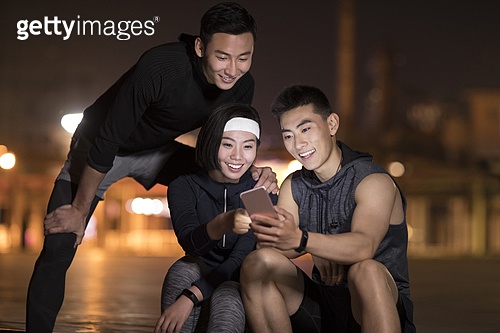 Young Chinese friends using smart phone 이미지 (a11096307) - 게티이미지뱅크