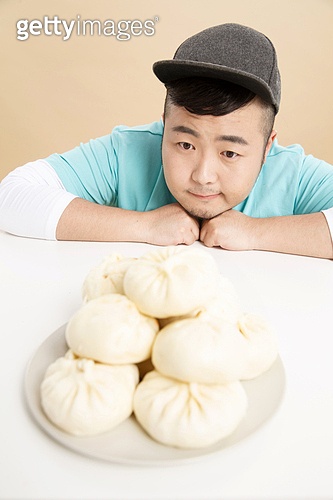 Little fat man to eat steamed stuffed bun 이미지 (vs11131350) - 게티이미지뱅크