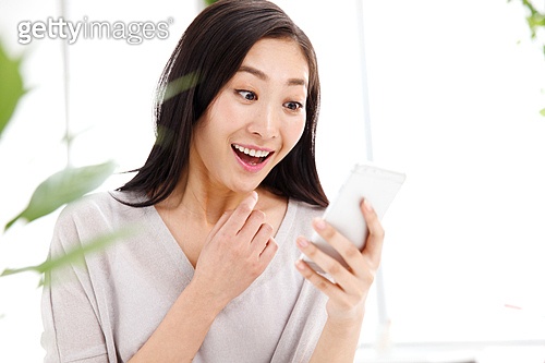 Young women carrying cell phone in the office 이미지 (vs11148350) - 게티이미지뱅크