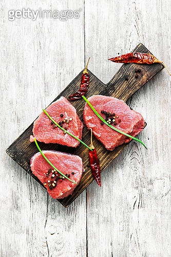Raw meat beef. raw chops veal steak with peppers and spices (a11912569 ...