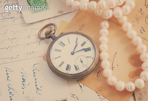 pile of old letters with antique clock and pearls, retro toned. old ...