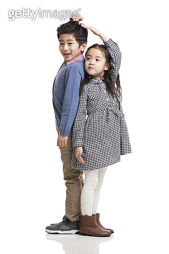 Two Chinese children measuring height 이미지 (a12298245) - 게티이미지뱅크