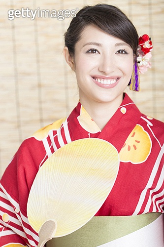 A woman in a yukata fanning a fan 이미지 (jv12360207) - 게티이미지뱅크