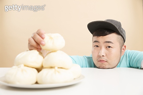 Small fat man eat steamed stuffed bun (vs12437805) - 게티이미지뱅크