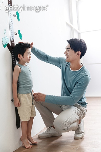 Dad in measuring height for the little boy 이미지 (vs12483327) - 게티이미지뱅크
