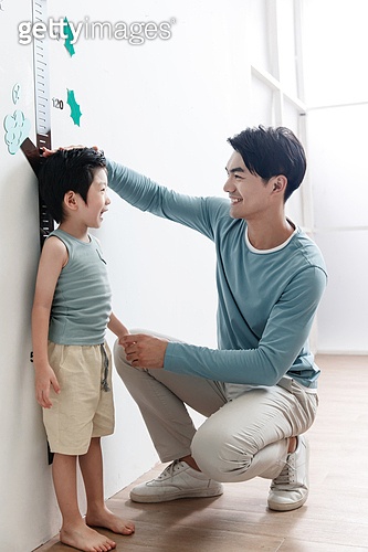 Dad in measuring height for the little boy 이미지 (vs12483866) - 게티이미지뱅크