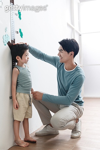 Dad in measuring height for the little boy 이미지 (vs12483892) - 게티이미지뱅크