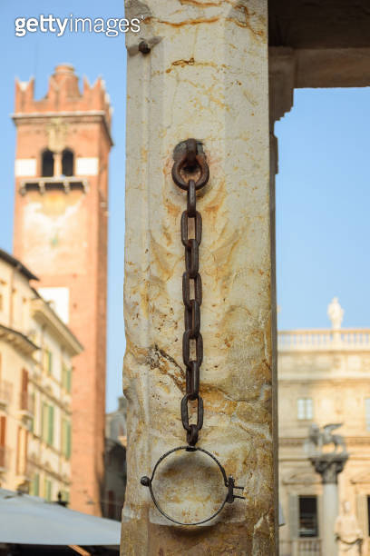 Medieval stone pillar, with rusty shackles for slaves and criminals ...