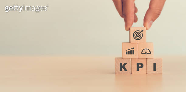 KPI, Key Performance Indicator. Businessman holds cube with KPI icon ...