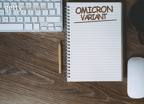 Desktop flat lay of note book with the title of Omicron Variant of ...
