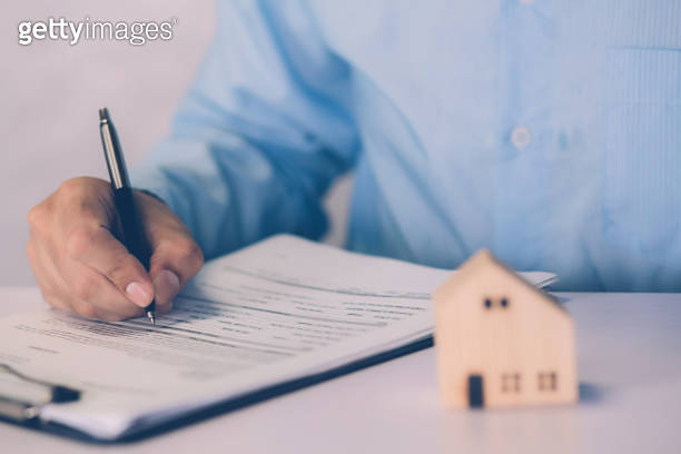 Real estate agent holding home and signing contract about agreement of ...