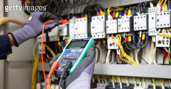 Electrician engineer tests electrical installations and wires on relay ...