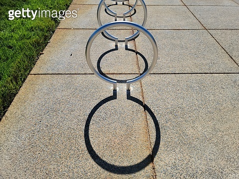 circular metal bike rack with curved shadows on cement 이미지 (1348814717 ...