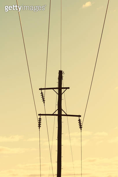 Photograph of a wooden telephone post and cables against a blue sky 이미지 ...