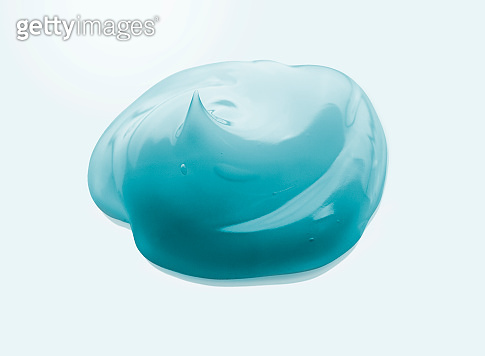 Smudged light blue textured lip balm droplet on white isolated ...
