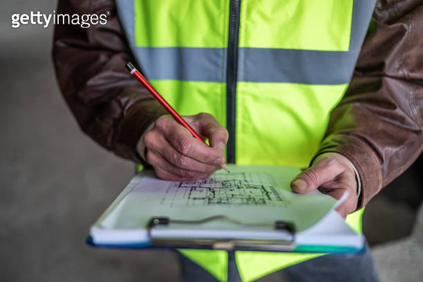 Portrait of engineer reading plans on construction site. A civil ...