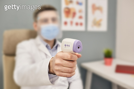 Close-up shot of general practitioner using infrared thermometer ...