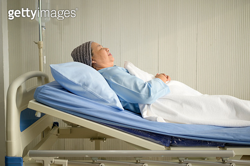 Depressed and hopeless Asian cancer patient woman wearing head scarf in ...