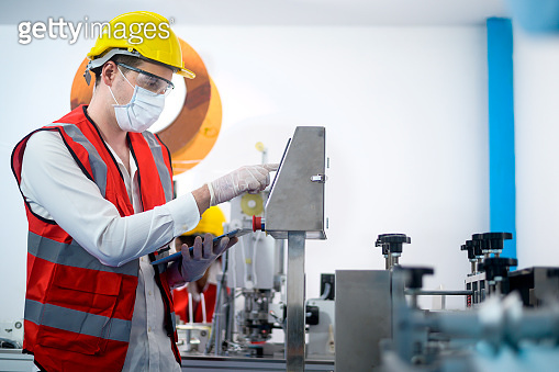 Quality control (QC) engineer monitoring and checking machine system in ...