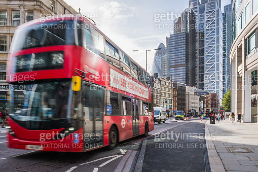 London red double decker bus zooming through City Financial District ...