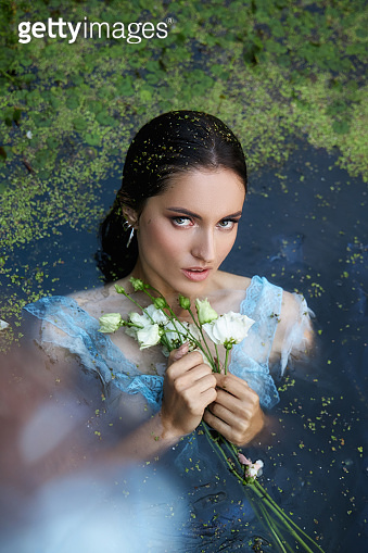 Art beautiful romantic woman lies in swamp in blue long dress with ...