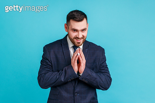 Portrait of devious handsome brunette man with beard wearing dark ...