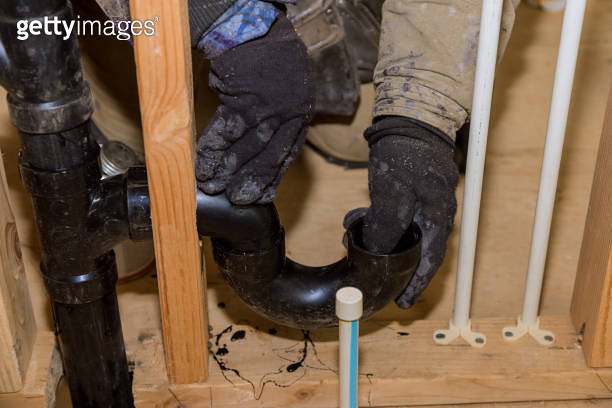 Worker using glue with fitting for installing the PVC drain pipe in the ...