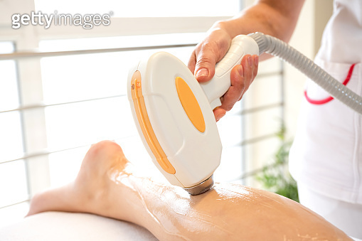 Close-up of a laser diode in the hand of an Aesthetician giving laser ...