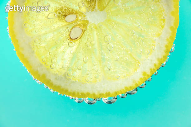 Lemon and line drop in fizzy sparkling water, juice refreshment 이미지 (1321845390) - 게티이미지뱅크