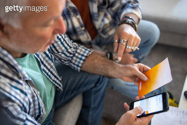 Senior man ordering delivery using mobile app on smartphone from home ...