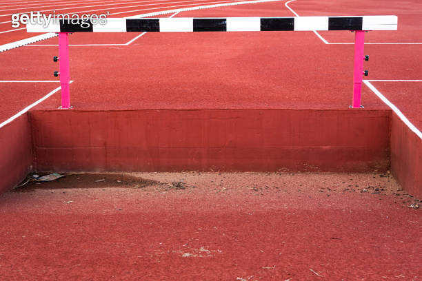 An obstacle fence for jumping over at the running race track ...