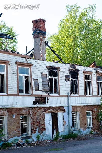 A wooden house burned down by a fire, the ruins of a building on a city ...