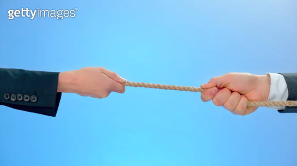 Male and female hand pulling rope 이미지 (1312271380) - 게티이미지뱅크