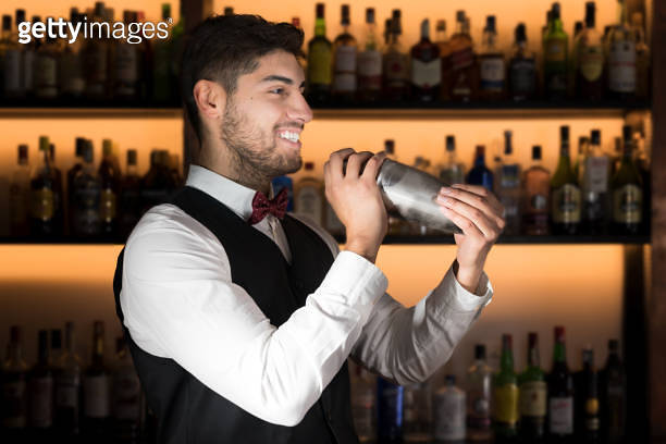Cool professional bartender making a cocktail, shaking a cocktail ...