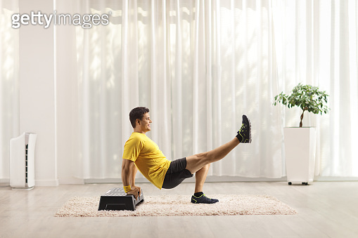 Man exercising on a step aerobic platform in a room 이미지 (1357522105 ...