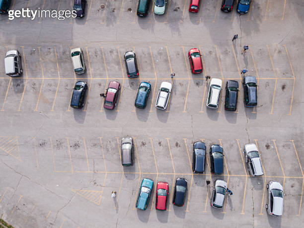 Aerial view over parking lot in the rush hour after work in a medium ...