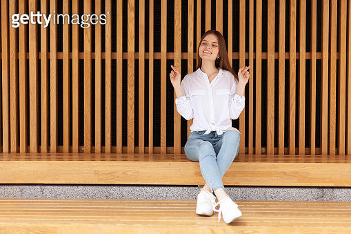 Waiting for luck. A young woman sits with crossed fingers and hopes for ...