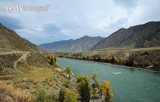 The road goes along the cliff of a high cliff going through a valley ...