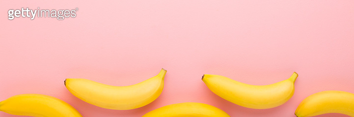 Beautiful fresh yellow bananas on light pink table background. Pastel ...